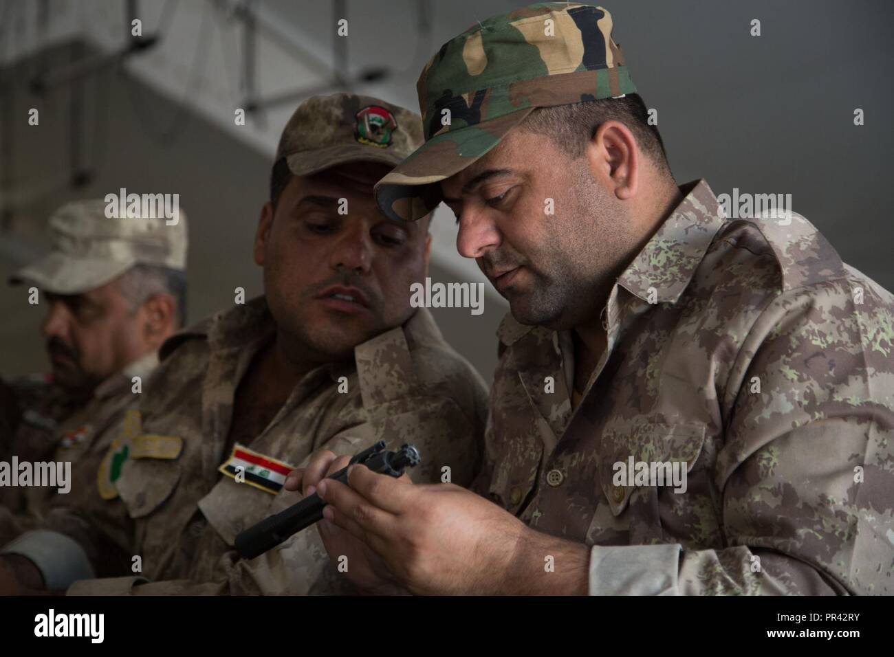 An Iraqi soldier disassembles his weapon during M16 familiarization at ...