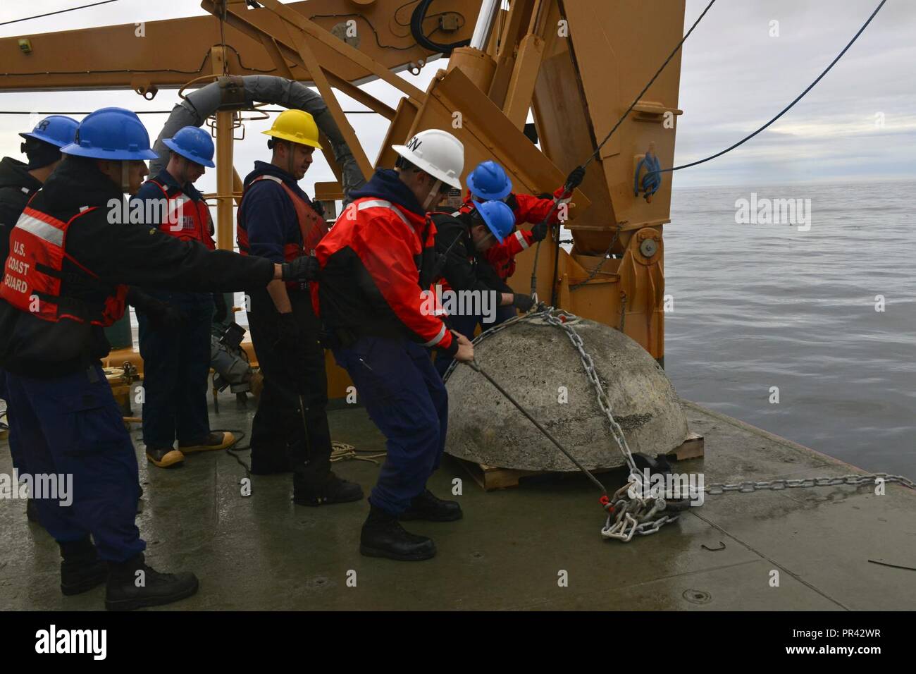 Coast Guard Cutter Healy crew members prepare to lower a buoy anchor in ...