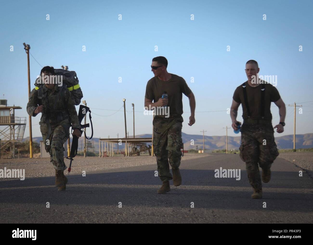 Spc. Ryan Gaetz (right) and Sgt. Kelton Sphaler (middle) runs alongside ...
