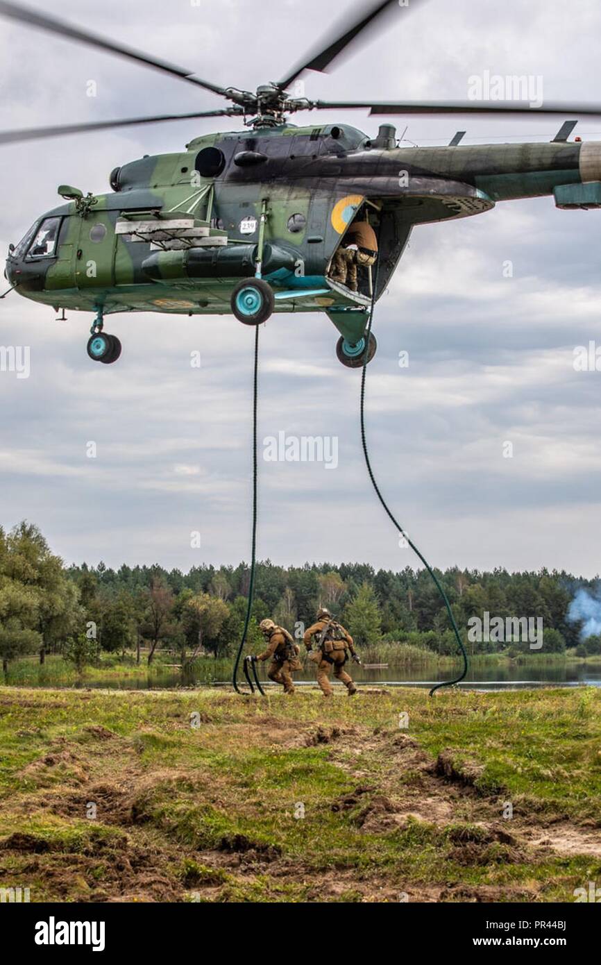 Ukrainian Soldiers repel out of a helicopter to perform a medevac ...
