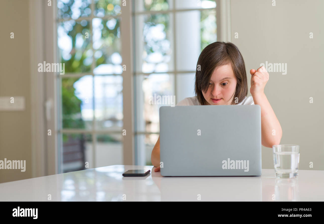 Down syndrome woman at home using computer laptop annoyed and ...