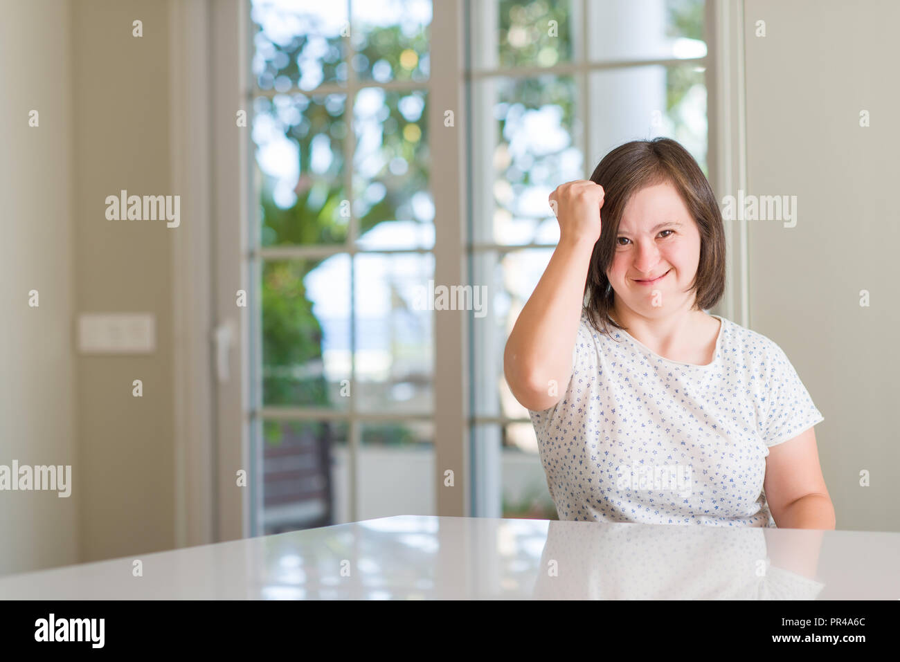 Down syndrome woman at home annoyed and frustrated shouting with anger ...