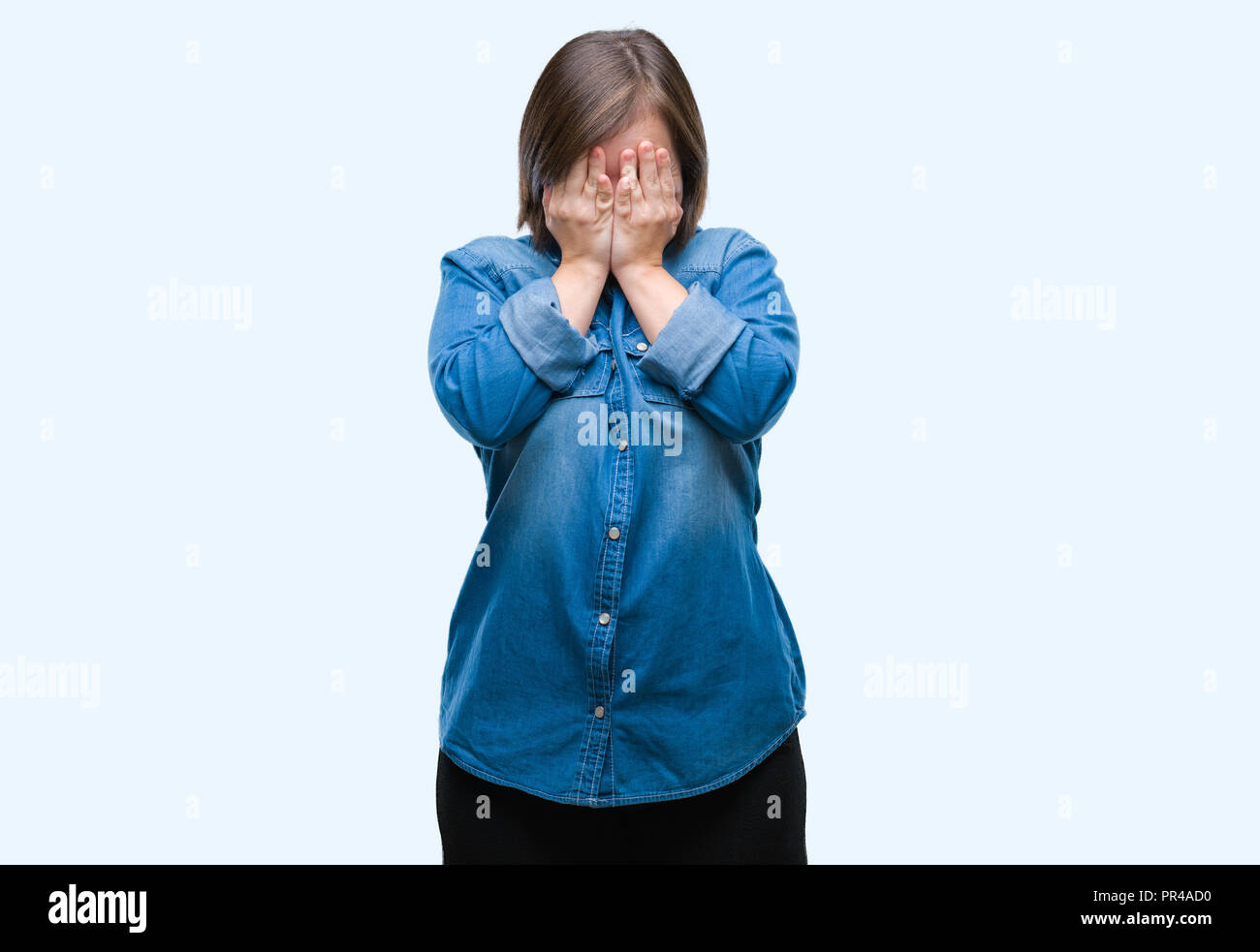 Young adult woman with down syndrome over isolated background with sad ...