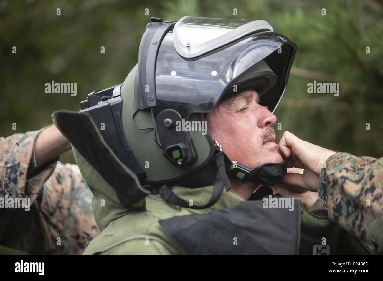 Sgt. Scott N. Schaller is assisted with fastening the helmet of his ...