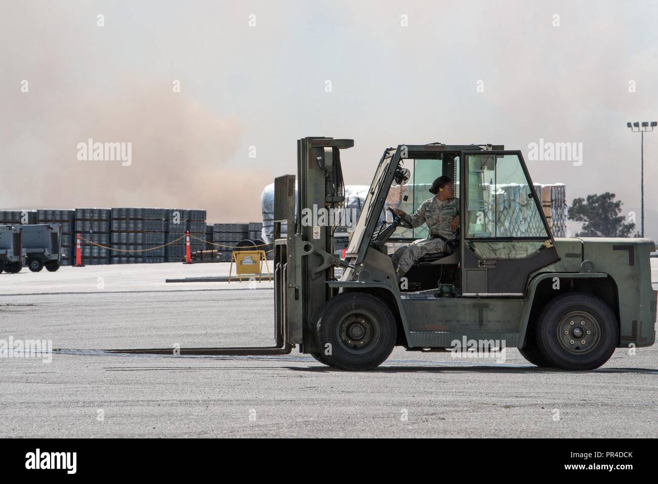An Airman from the 60th Aerial Port Squadron drives a forklift while a ...