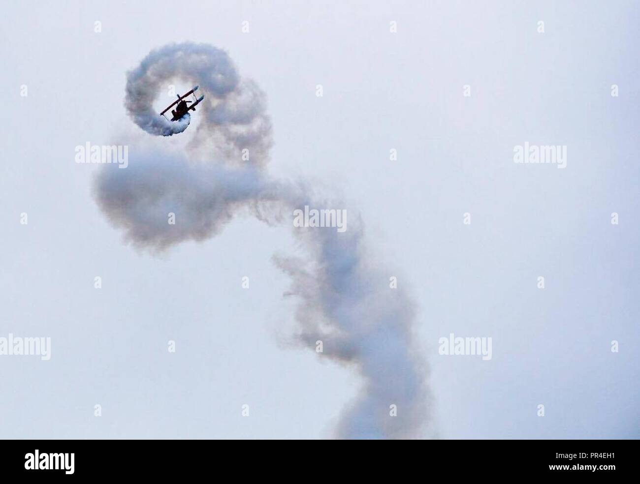 Brian Correll performs an aileron roll while popping smoke from his ...