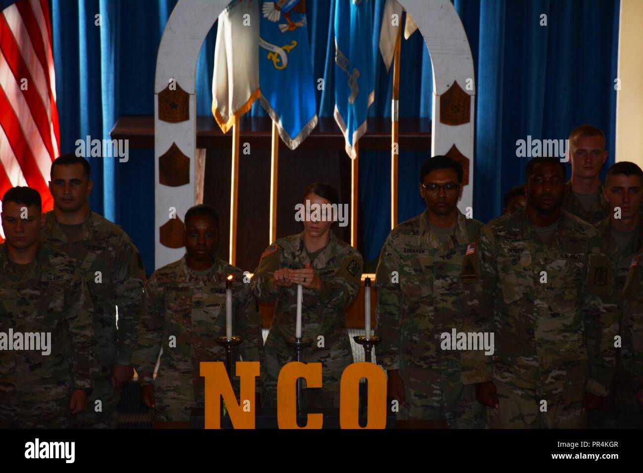 Sgt. Sarah Madrid, lights a candle, which signifies one of the three ...