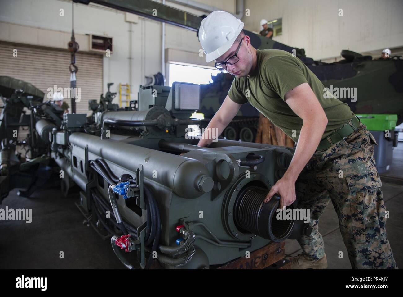 Cpl. Salvatore Ferrigno aligns a cannon tube during the reassembly of a ...