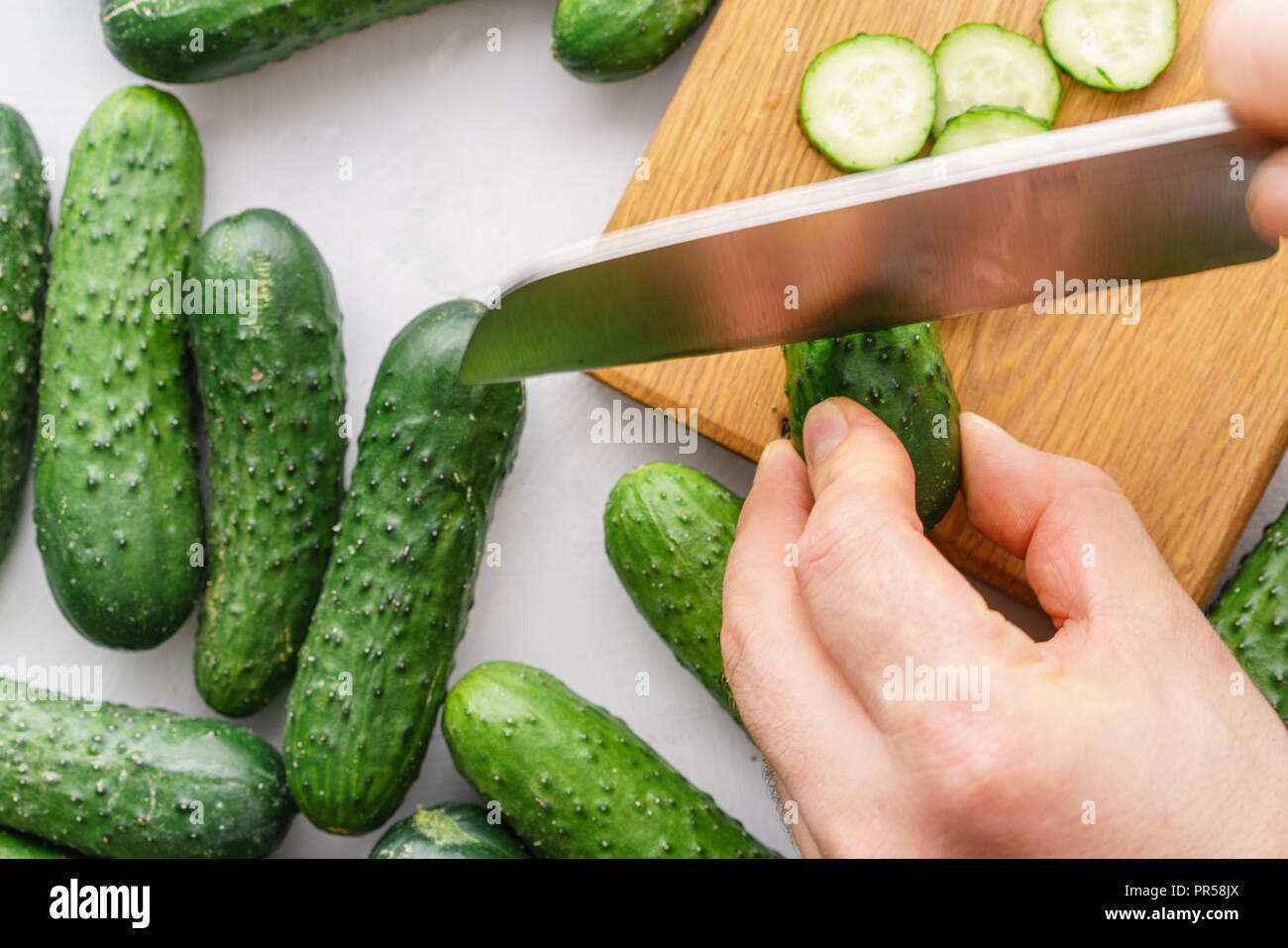 Mans hands cutting cucumbers for detox water. Top view. Process of ...