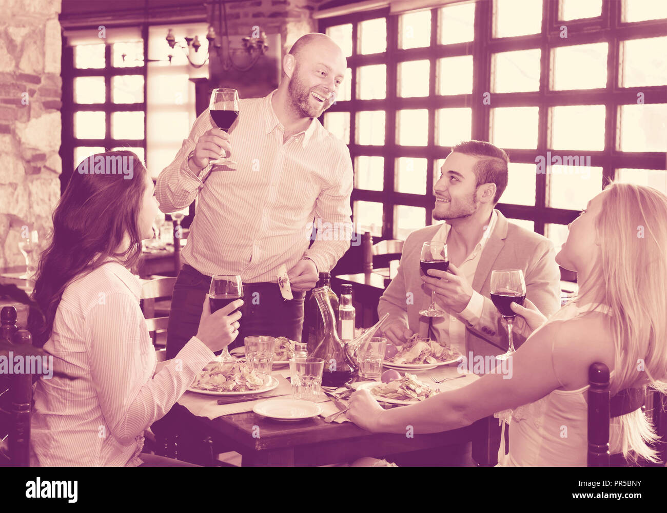 Two married couple sitting at restaurant table Stock Photo - Alamy