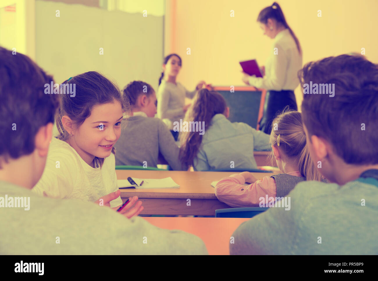 Happy students sitting desks hi-res stock photography and images - Alamy