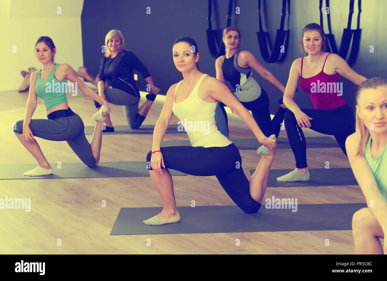 Young women exercising yoga poses in fitness center Stock Photo - Alamy