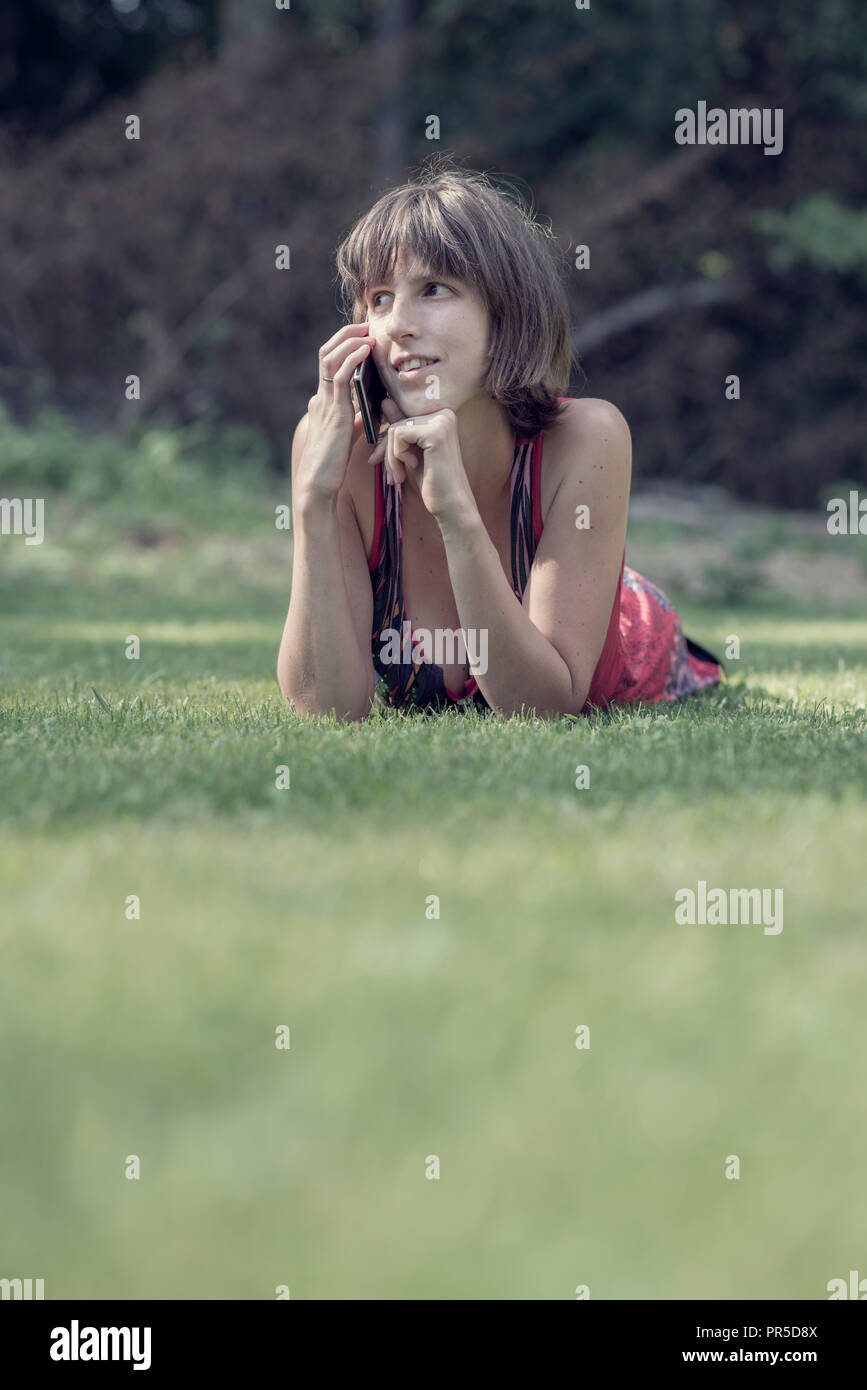 Woman lying on stomach on grass hi-res stock photography and images - Alamy