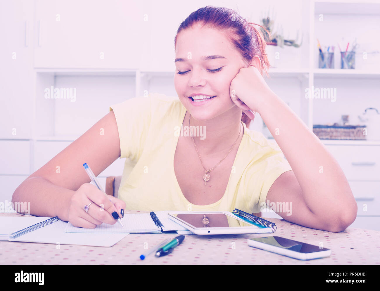 cheerful young female teenager studying with notes indoors Stock Photo ...