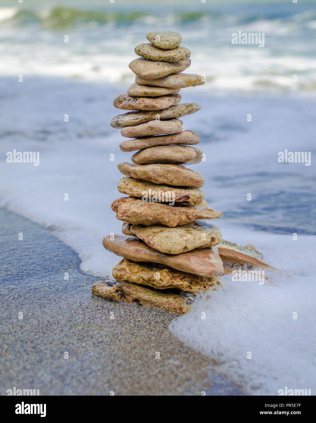 Man made rock formation, tower, on the beach, with waves Stock Photo ...