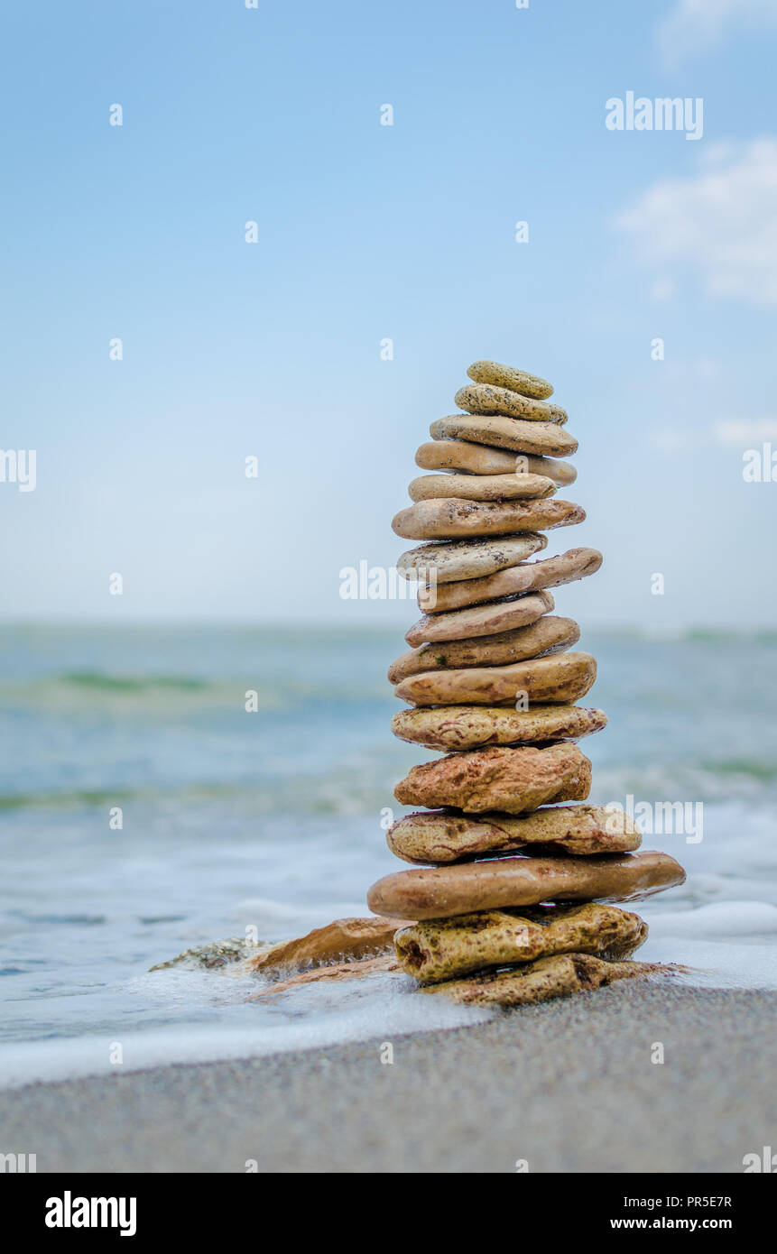 Man made rock formation, tower, on the beach, with waves Stock Photo ...