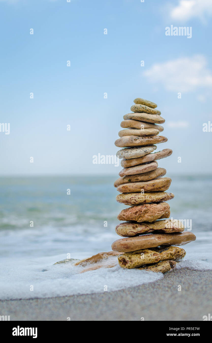 Man made rock formation, tower, on the beach, with waves Stock Photo ...