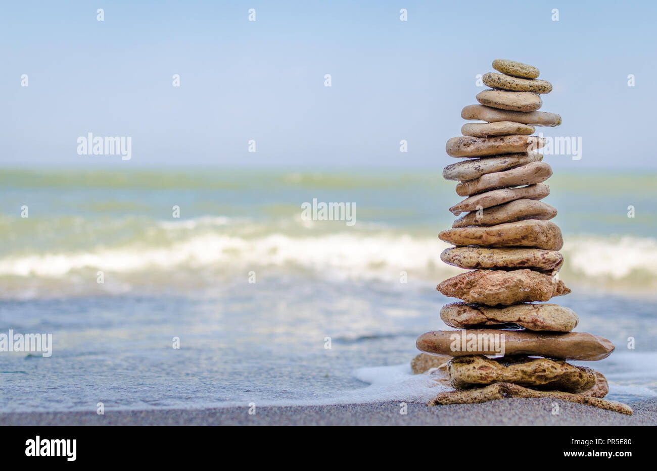 Man made rock formation, tower, on the beach, with waves Stock Photo ...