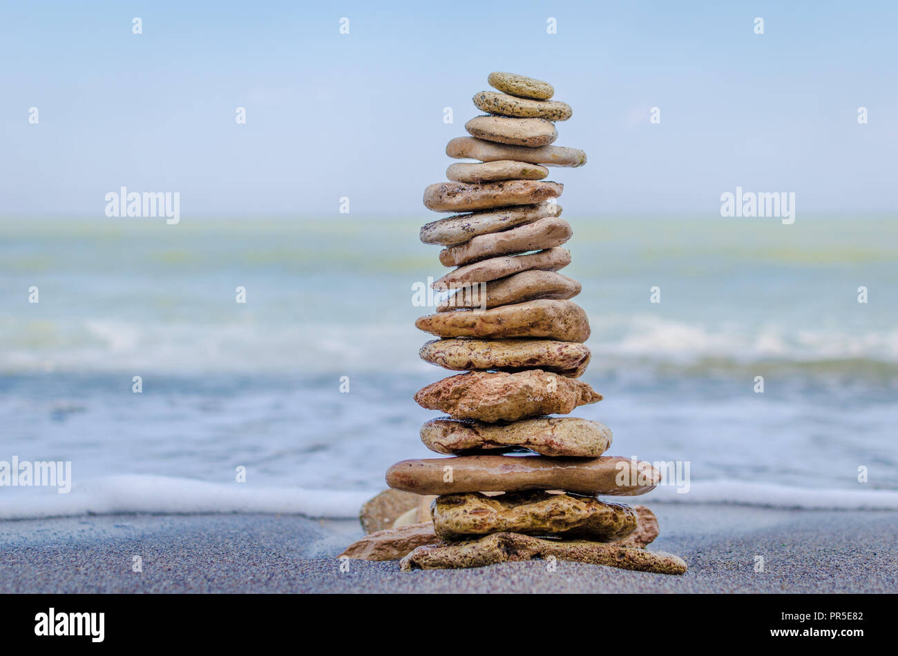Man made rock formation, tower, on the beach, with waves Stock Photo ...
