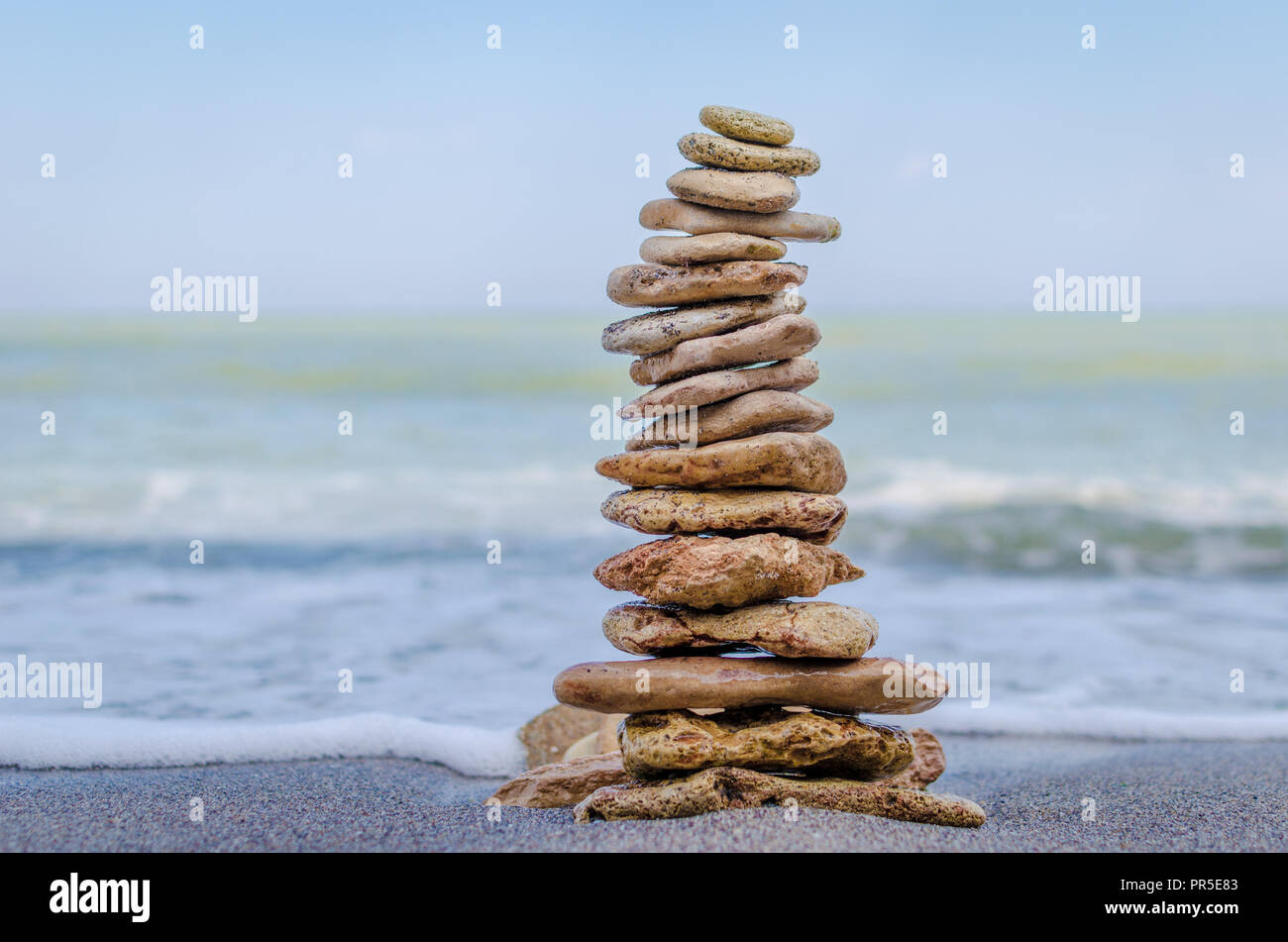 Man made rock formation, tower, on the beach, with waves Stock Photo ...