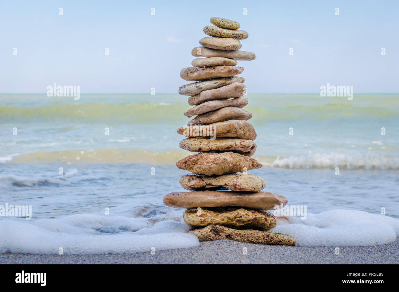 Man made rock formation, tower, on the beach, with waves Stock Photo ...