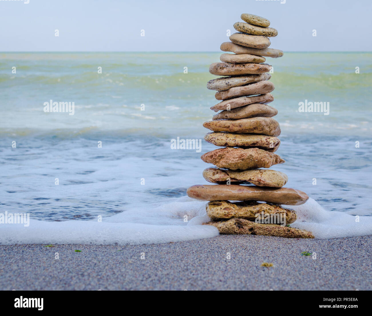 Man made rock formation, tower, on the beach, with waves Stock Photo ...