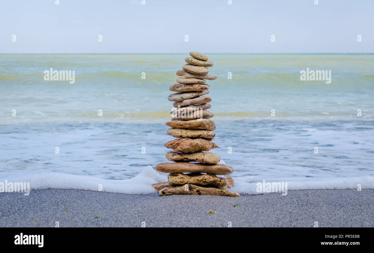 Man made rock formation, tower, on the beach, with waves Stock Photo ...