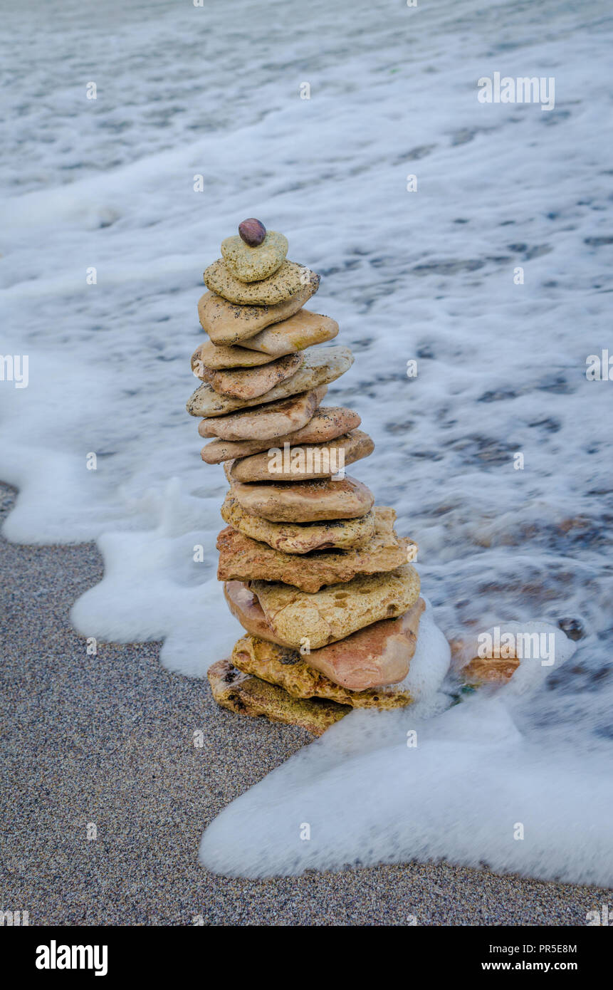 Man made rock formation, tower, on the beach, with waves Stock Photo ...