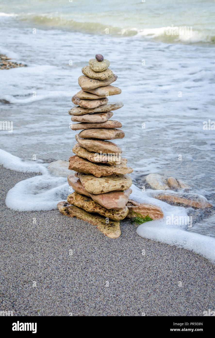 Man made rock formation, tower, on the beach, with waves Stock Photo ...