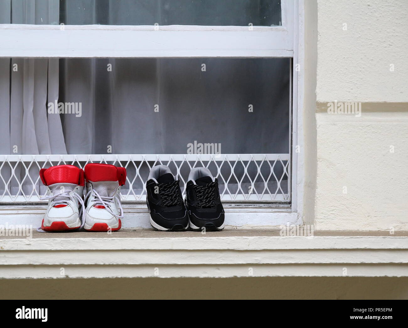 Sneakers in the window of an old house Stock Photo - Alamy