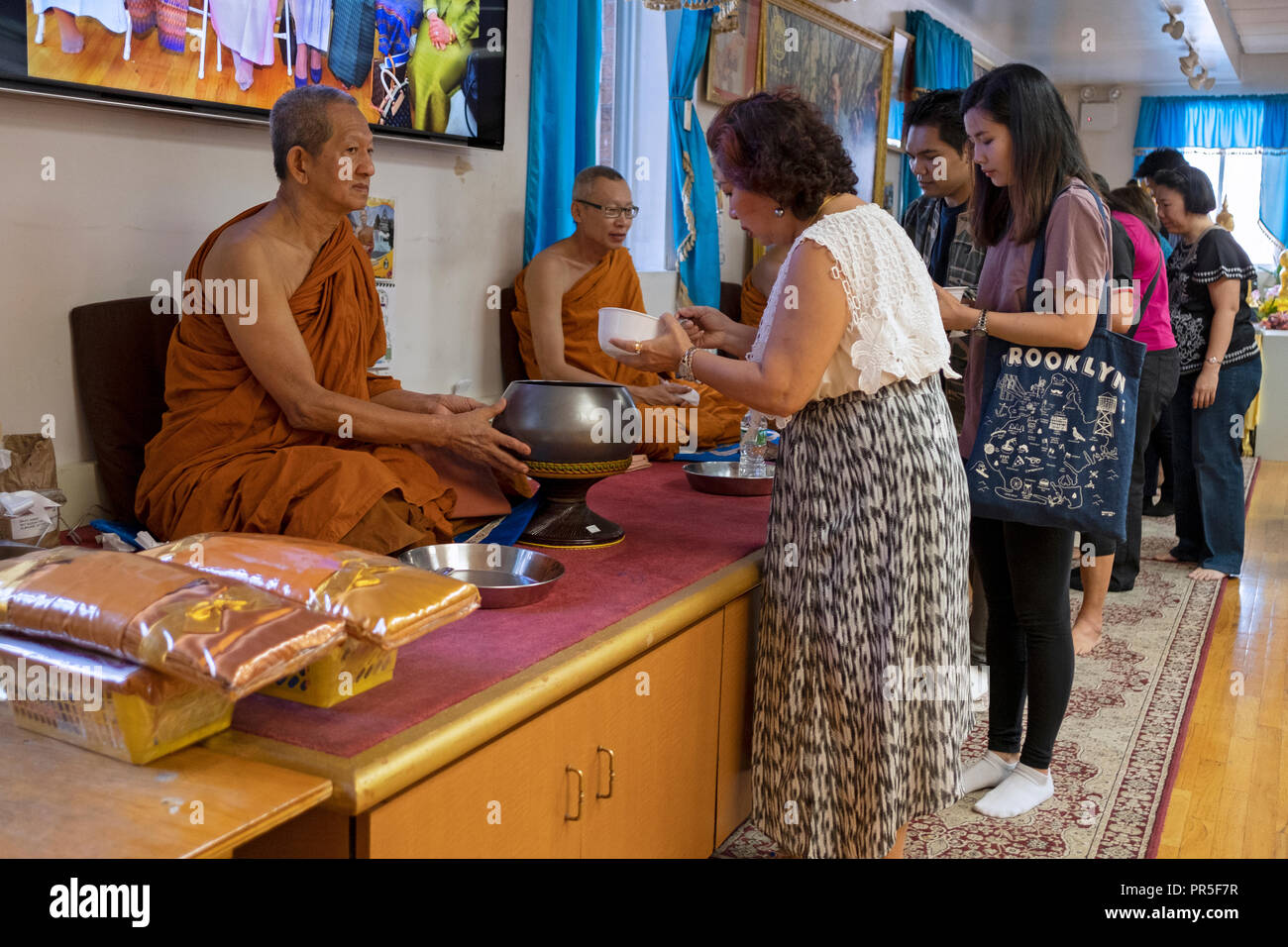 Worshipers at a Buddhist temple participate in the tradition where the ...