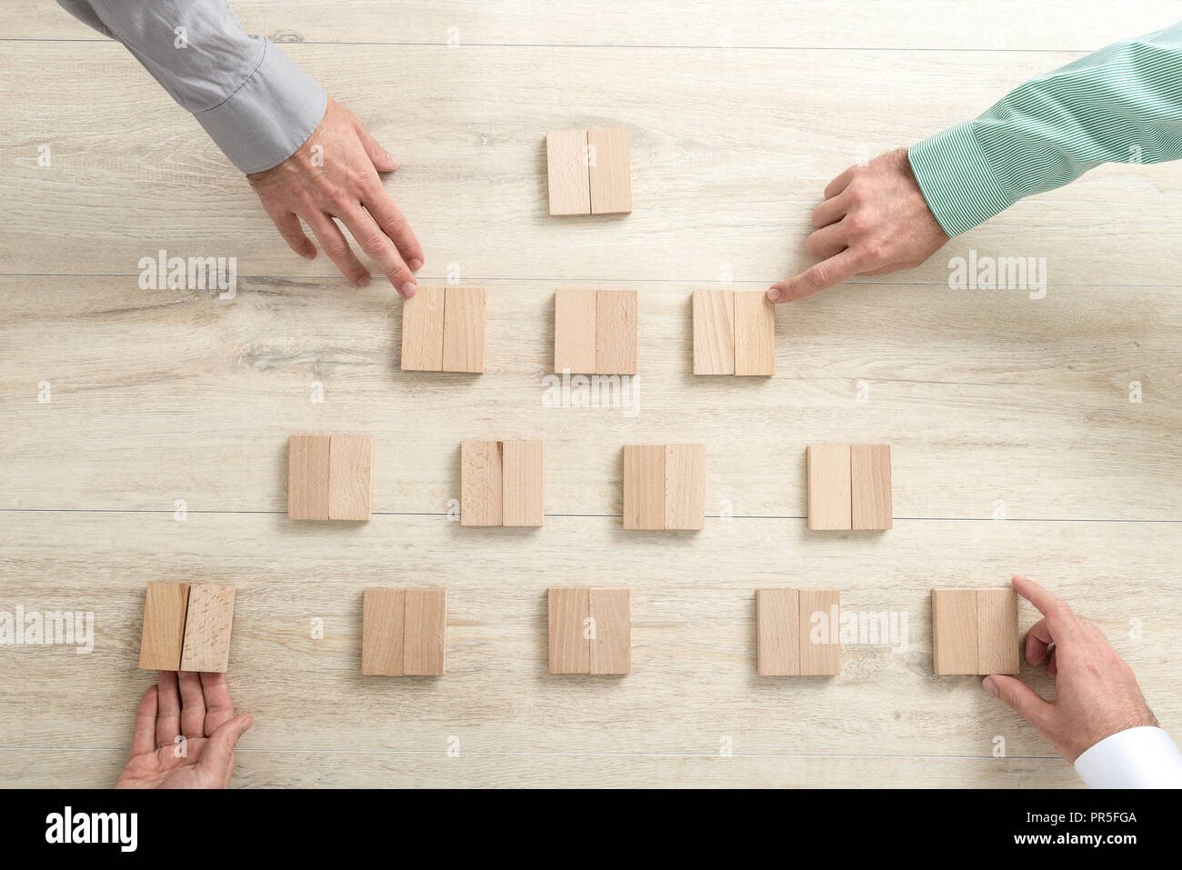 Top view of four businessmen placing empty wooden blocks in a form of a ...
