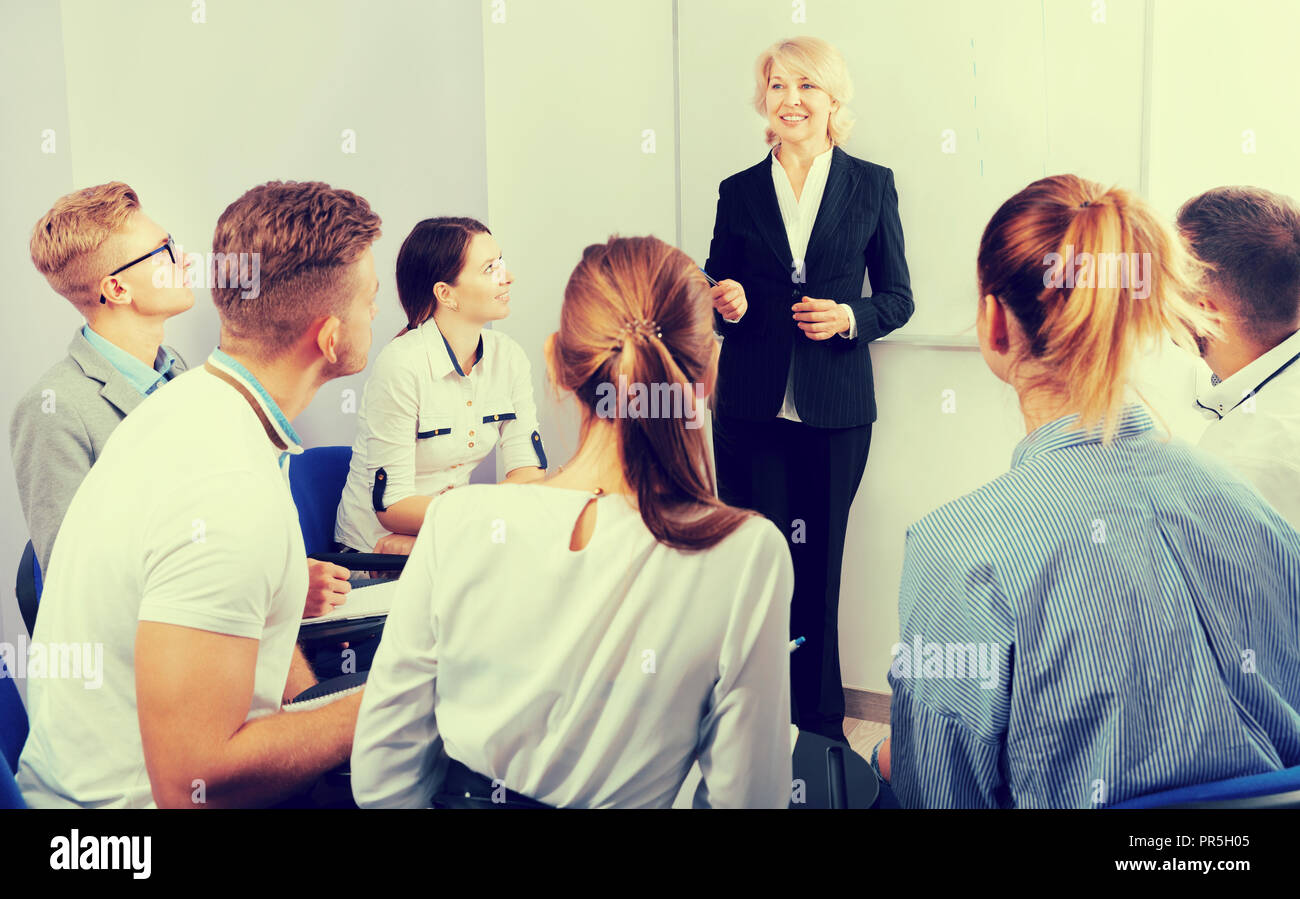 Elegant female teacher lecturing to the students in auditorium Stock ...