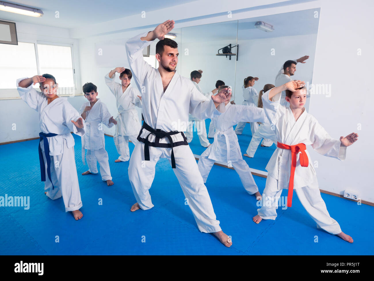 Young coach is training teenagers in karate class Stock Photo - Alamy