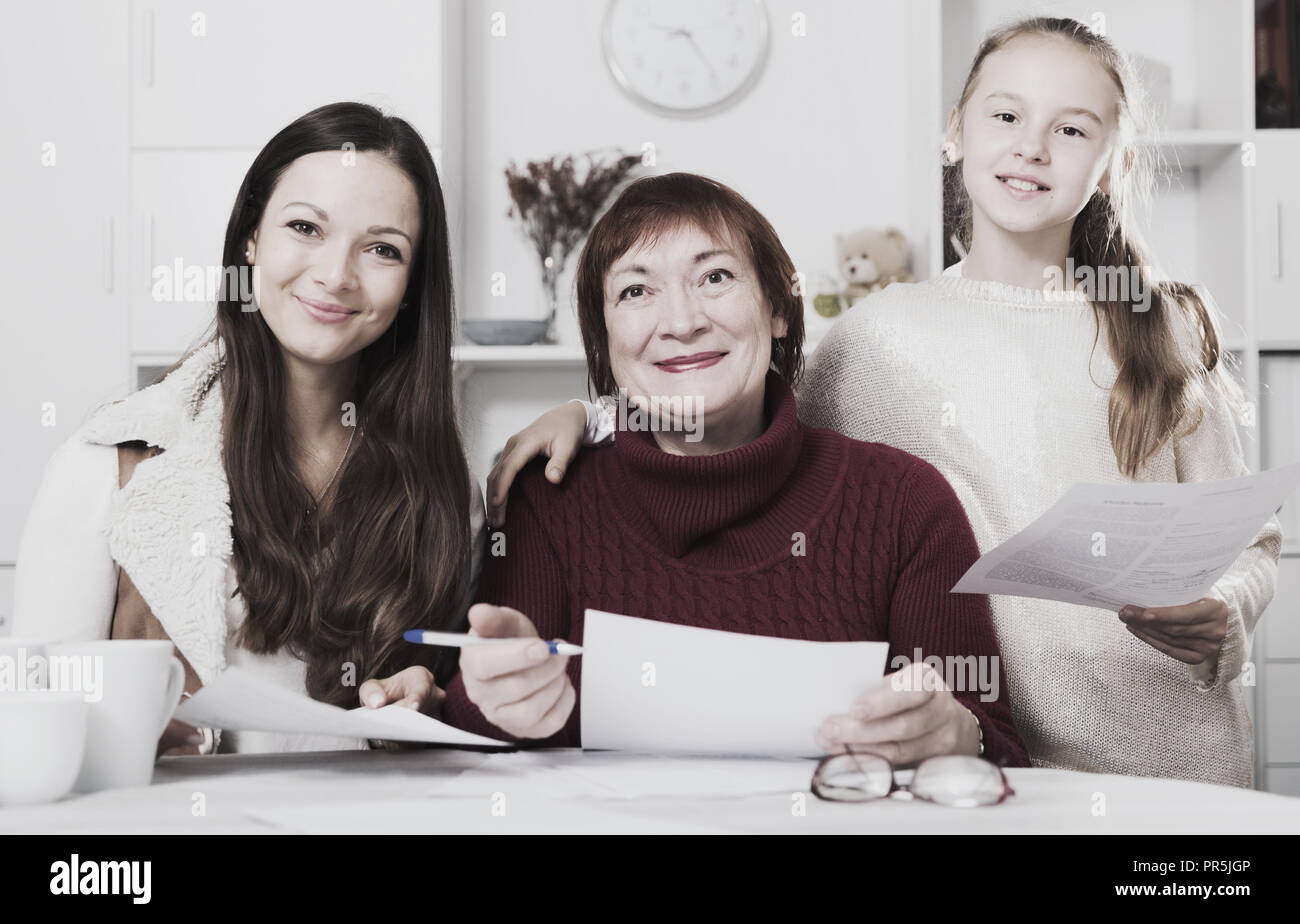 Three generations of happy family working together with documents at ...