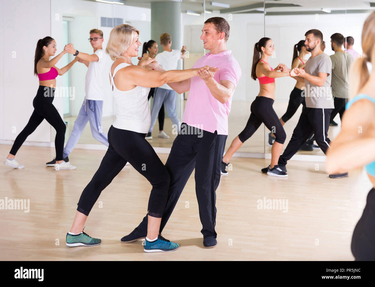 Dancing positive spanish couples learning salsa at dance class Stock ...