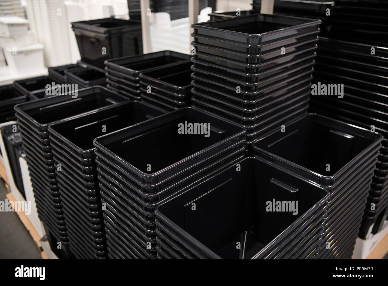 Black plastic box containers in row at store Stock Photo - Alamy