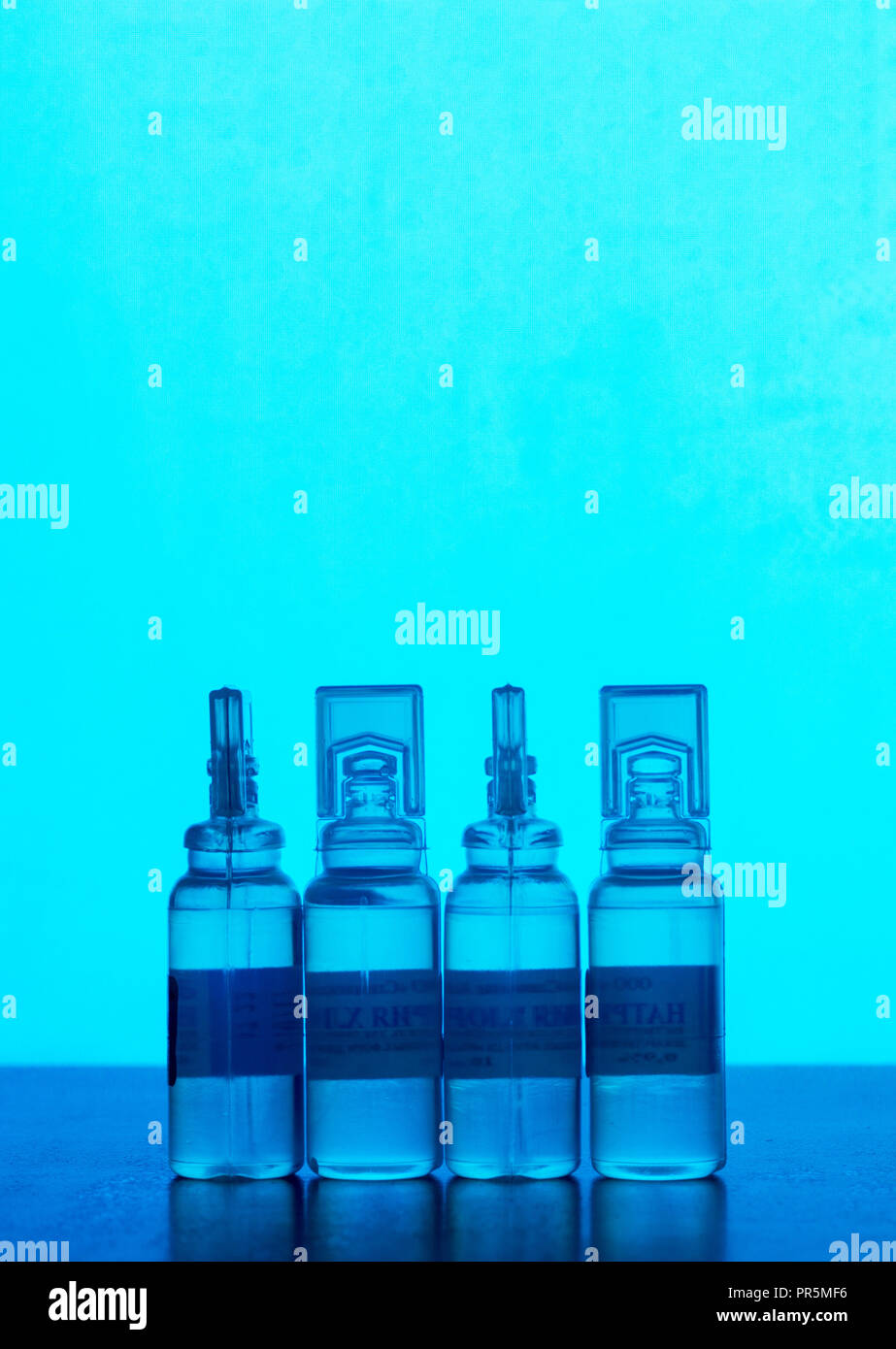 Plastic ampoules with solution for injections on the blue background ...