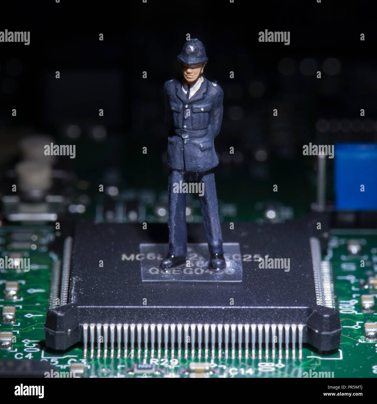 A toy policeman on top of a printed circuit board - concept cyber ...