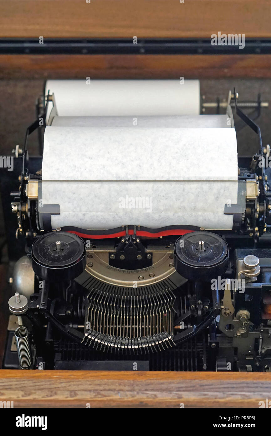 Typewriter machine with white paper in roll Stock Photo - Alamy