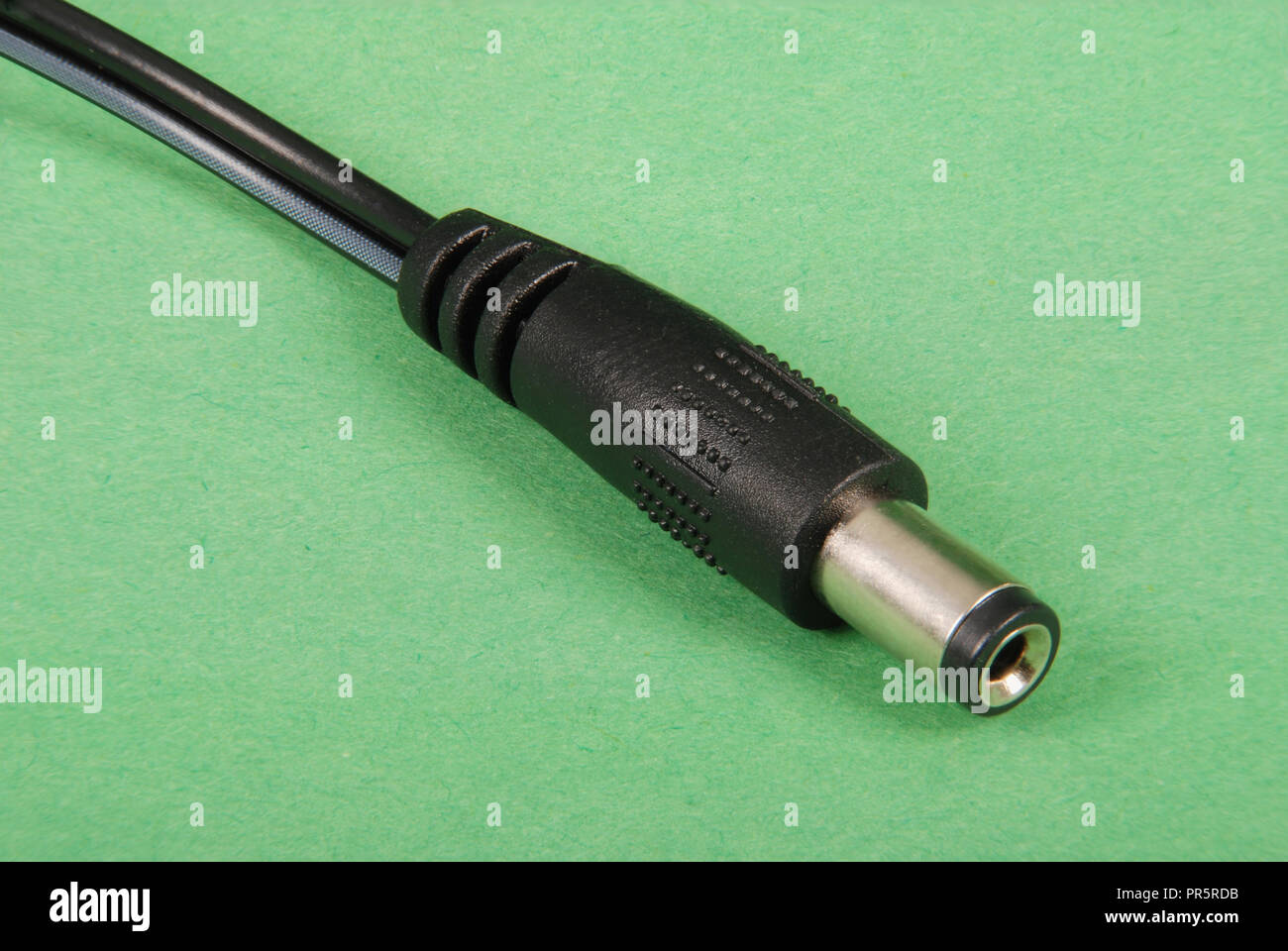 Black plug of power charger of laptop isolated on green background ...