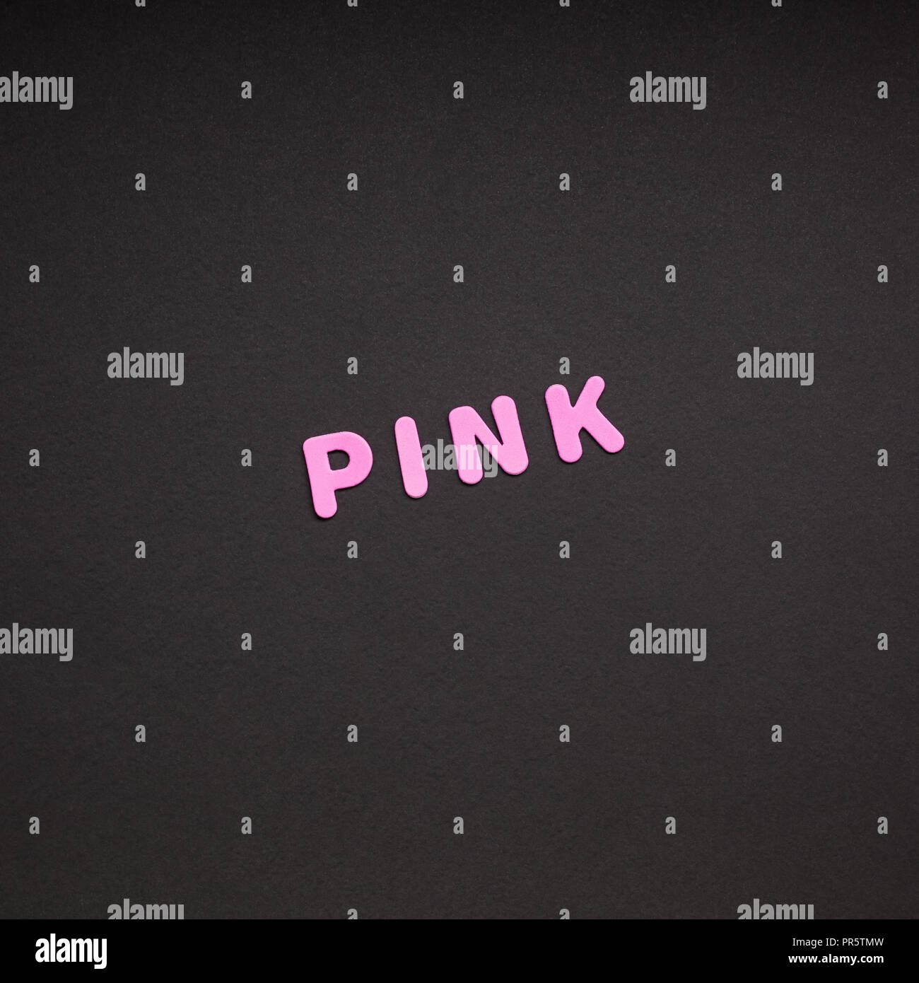 Creative colorful text made from plastic letters pink writing on black ...