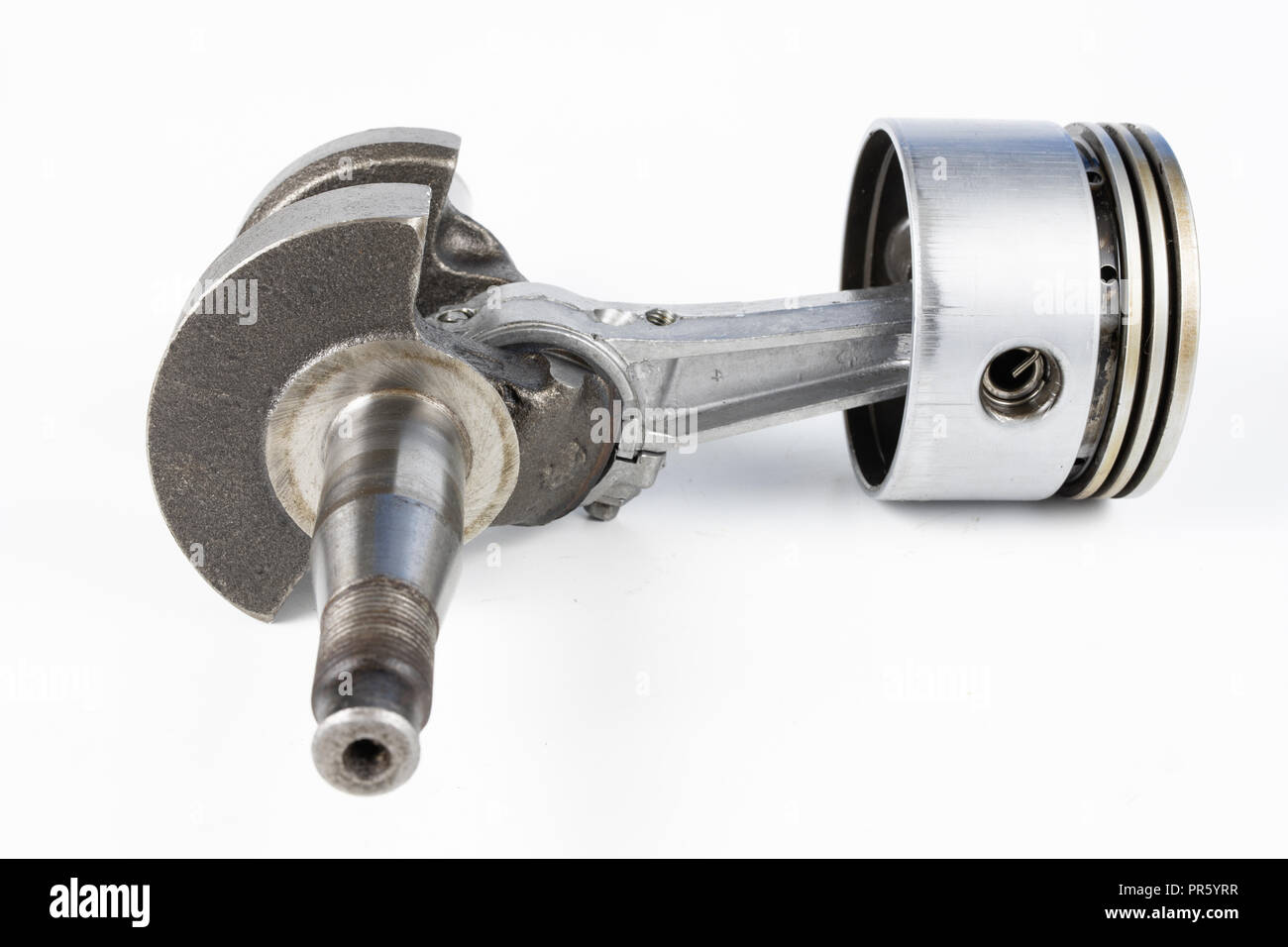 Crankshaft and piston of a small combustion engine on a white table ...