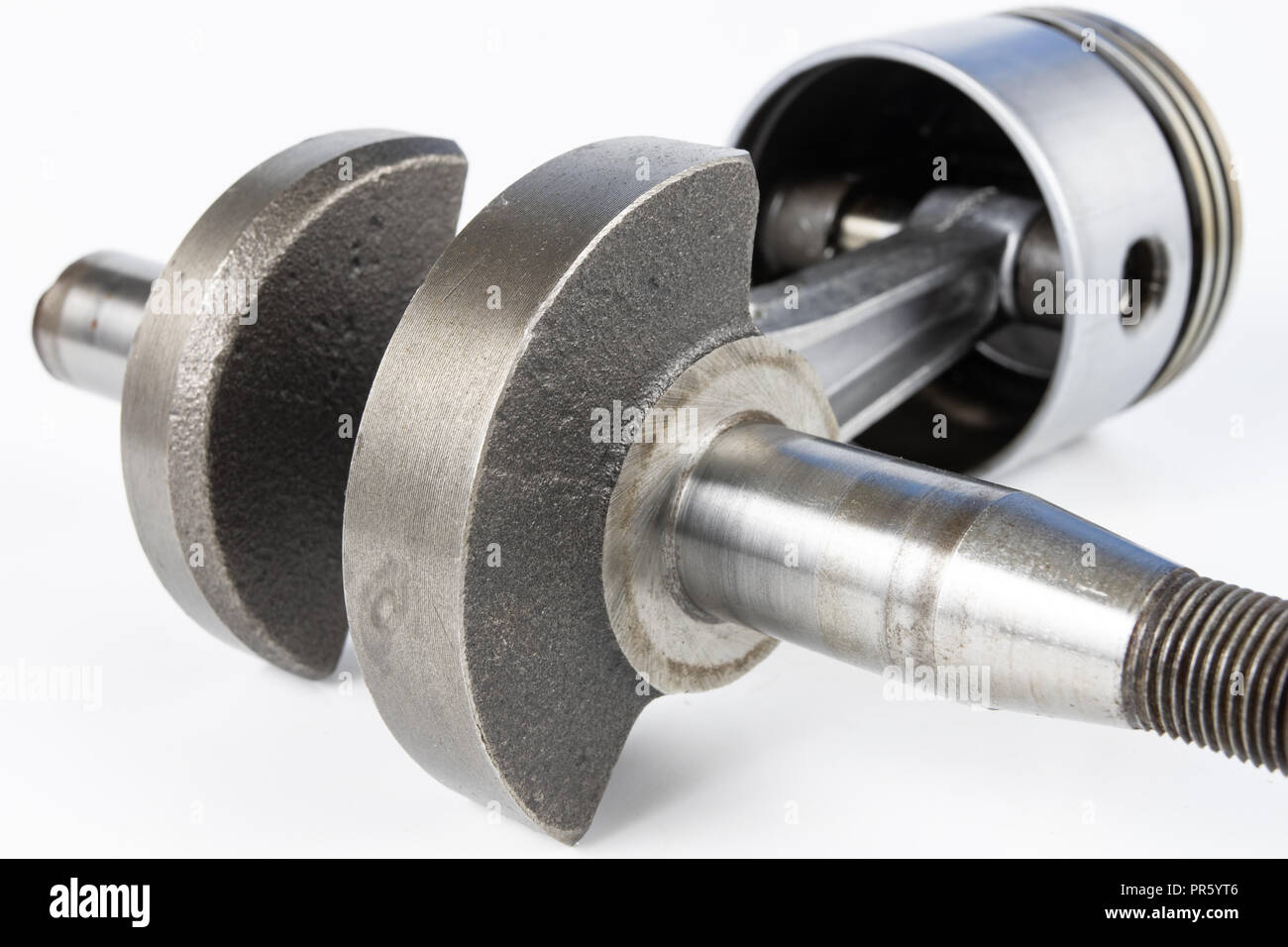 Crankshaft and piston of a small combustion engine on a white table ...