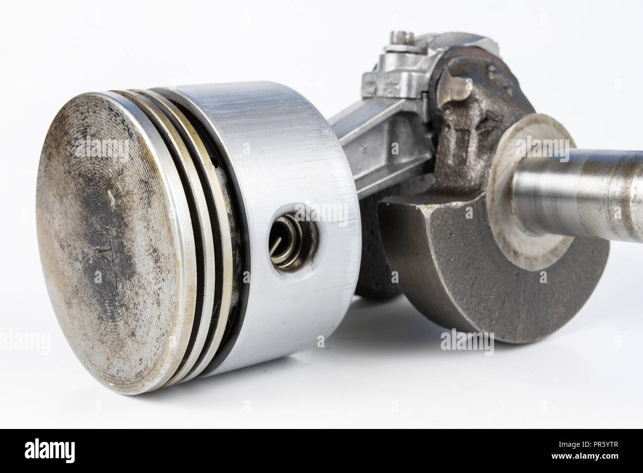 Crankshaft and piston of a small combustion engine on a white table ...