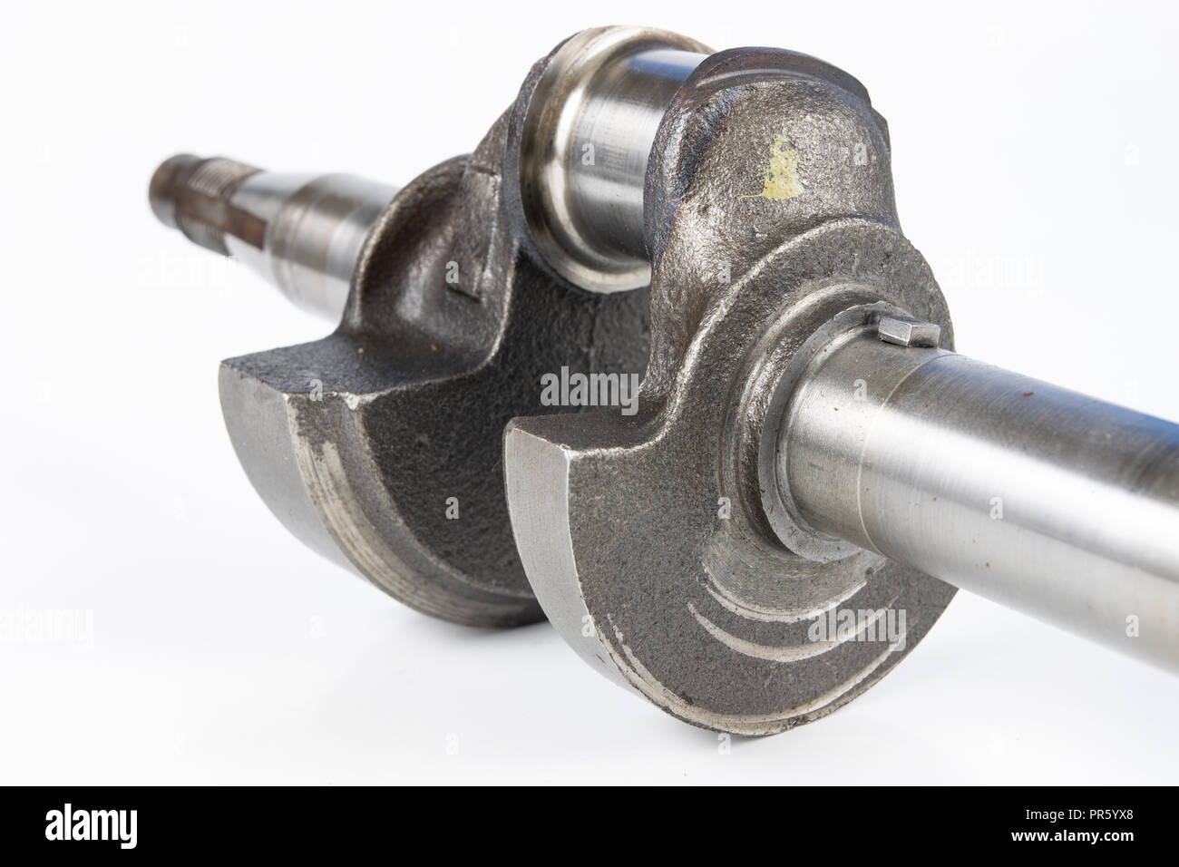 Crankshaft of a small combustion engine on a white table. Spare parts ...