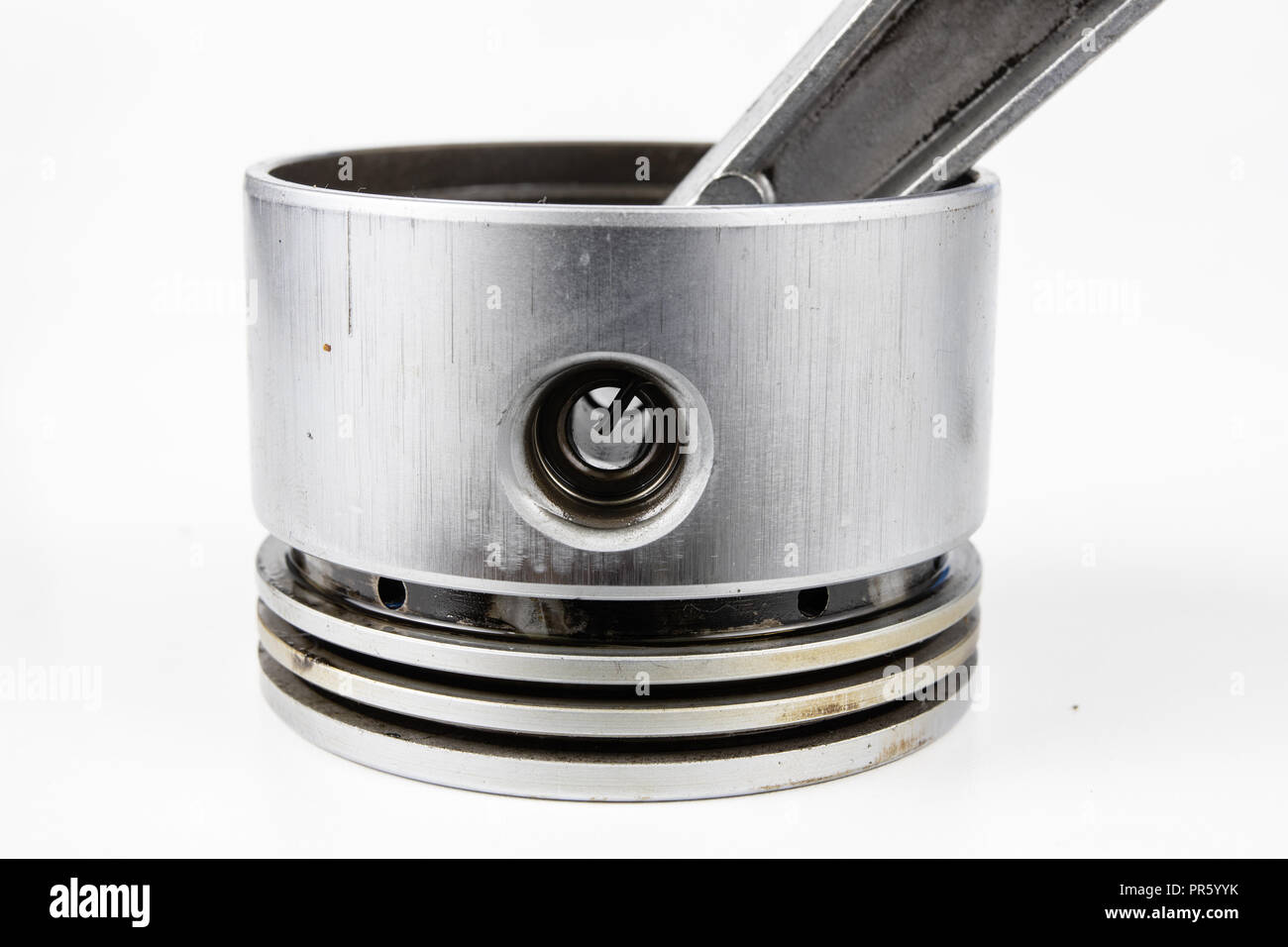 A small combustion engine piston on a white table. Spare parts for ...