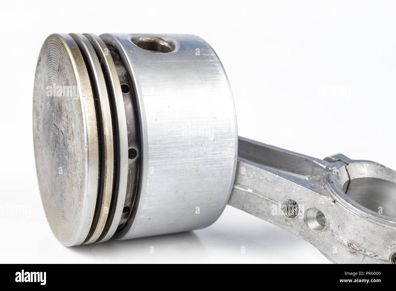 A small combustion engine piston on a white table. Spare parts for ...