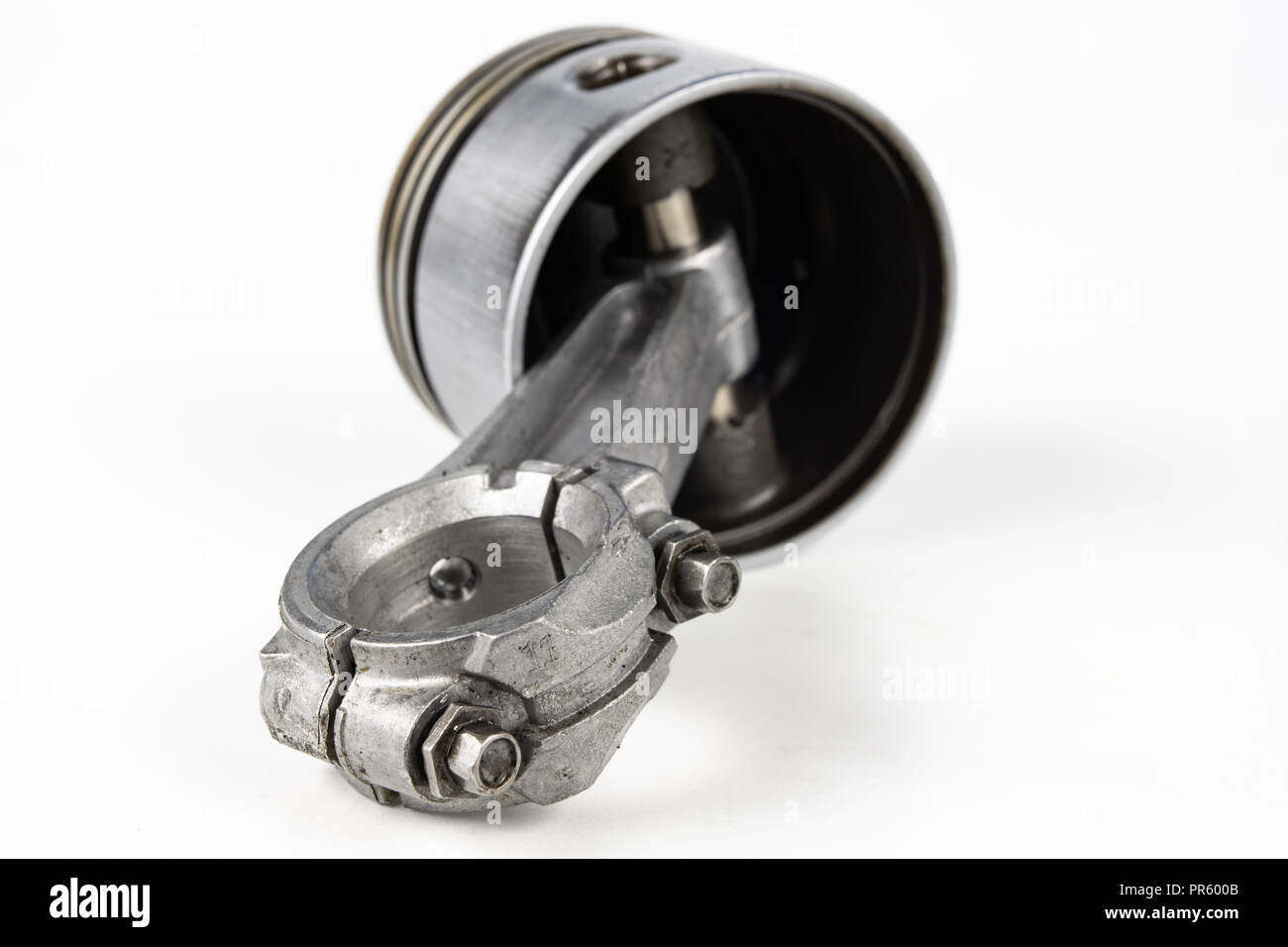 A small combustion engine piston on a white table. Spare parts for ...