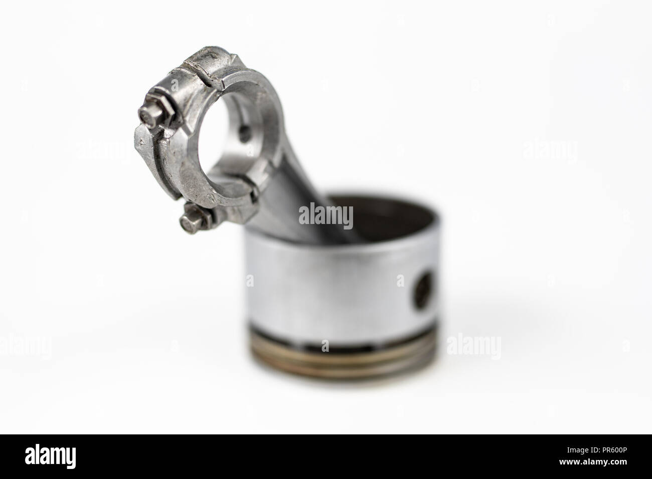 A small combustion engine piston on a white table. Spare parts for ...